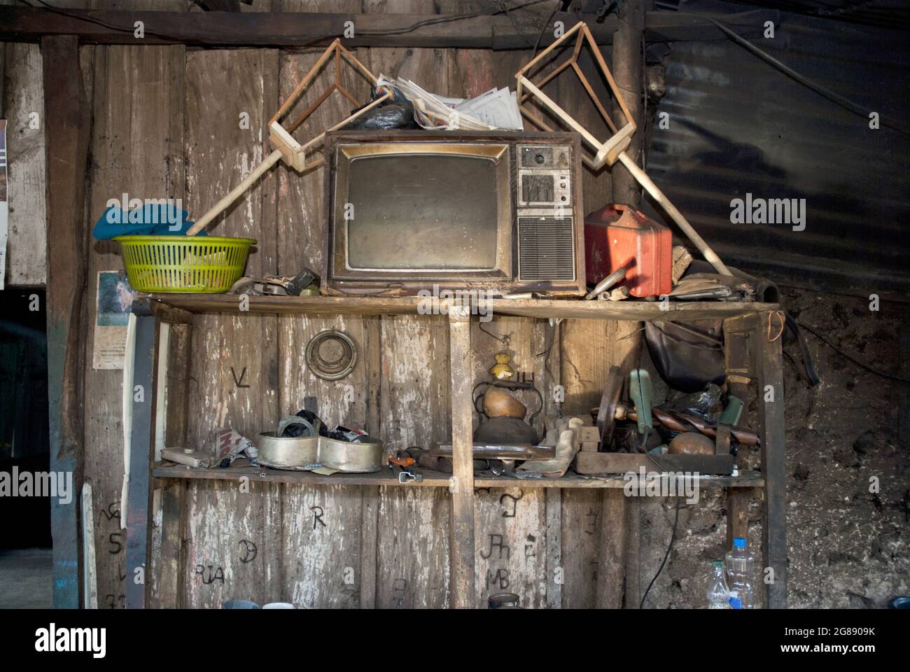 A view of accumulated and disordered objects on an old wooden shelf ...
