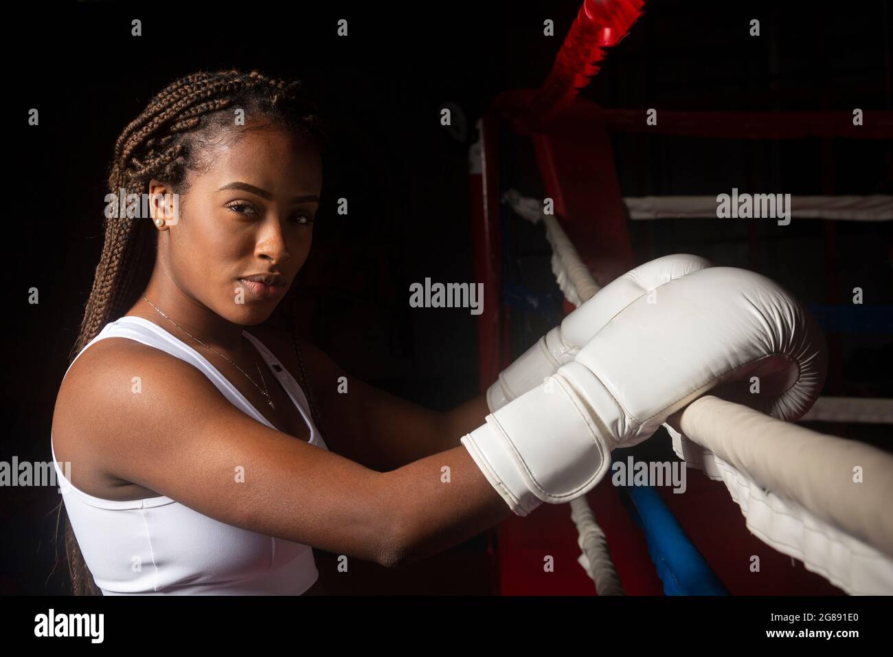 young black female athlete with boxing gloves looking at camera with ...
