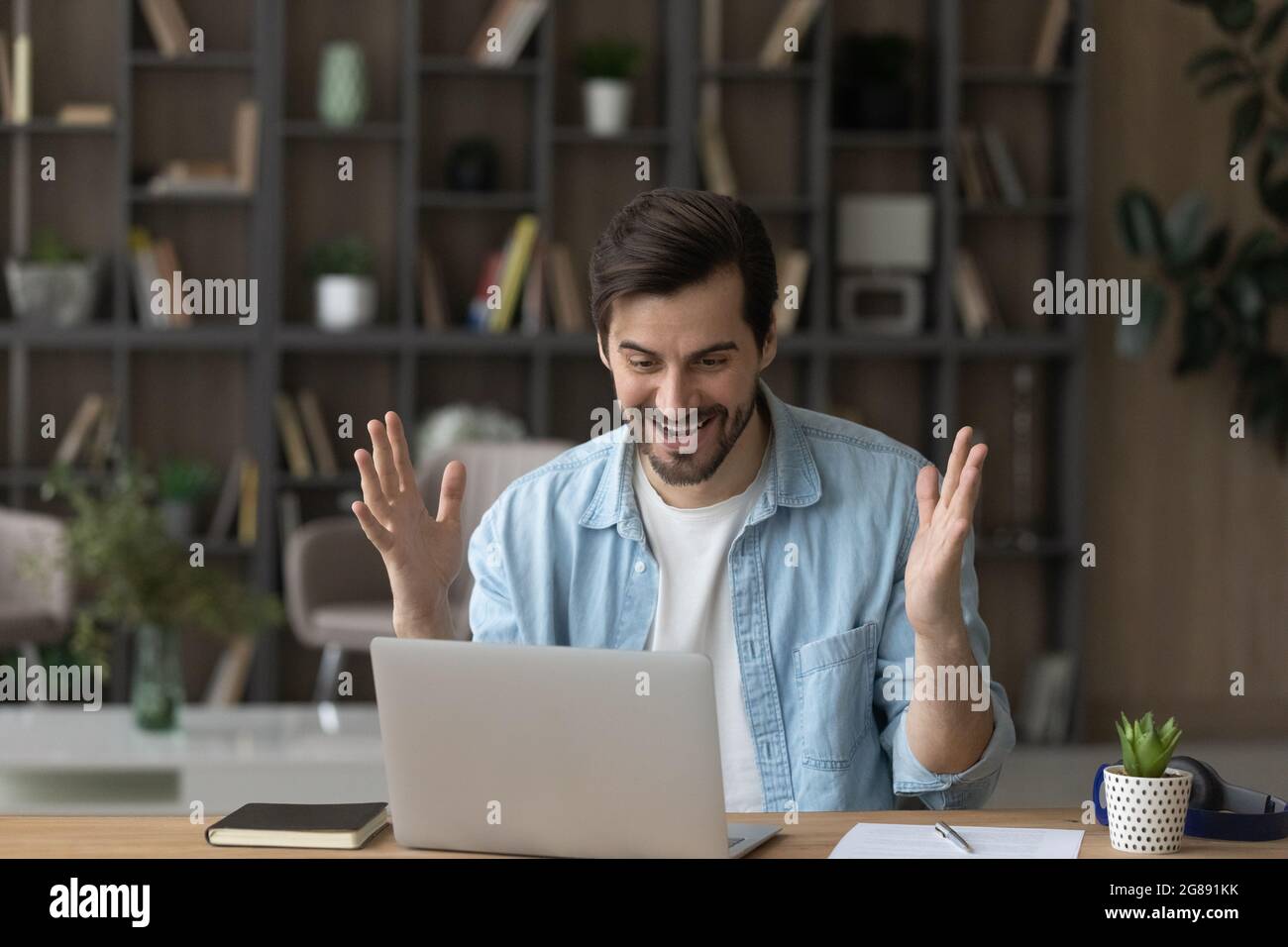 Emotional happy young man celebrating getting good news notification ...