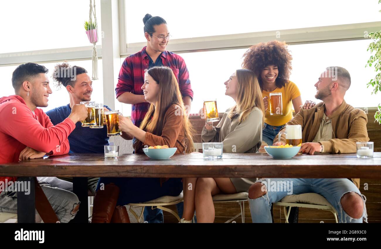 Happy multiracial friends fun toasting drinking beer on happy hour at ...