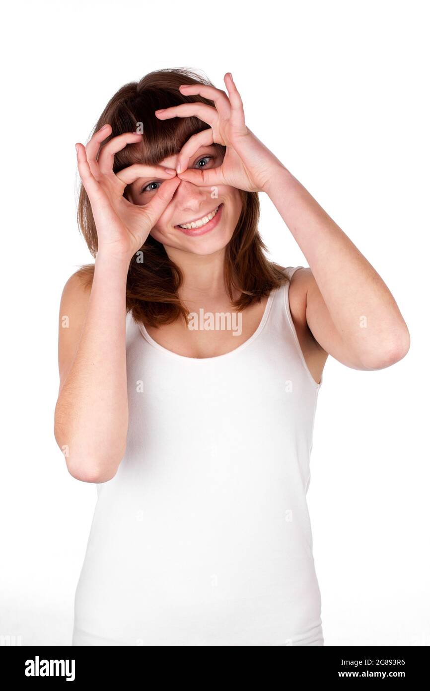 Young woman makes glasses with fingers. The girl looks in impromptu ...
