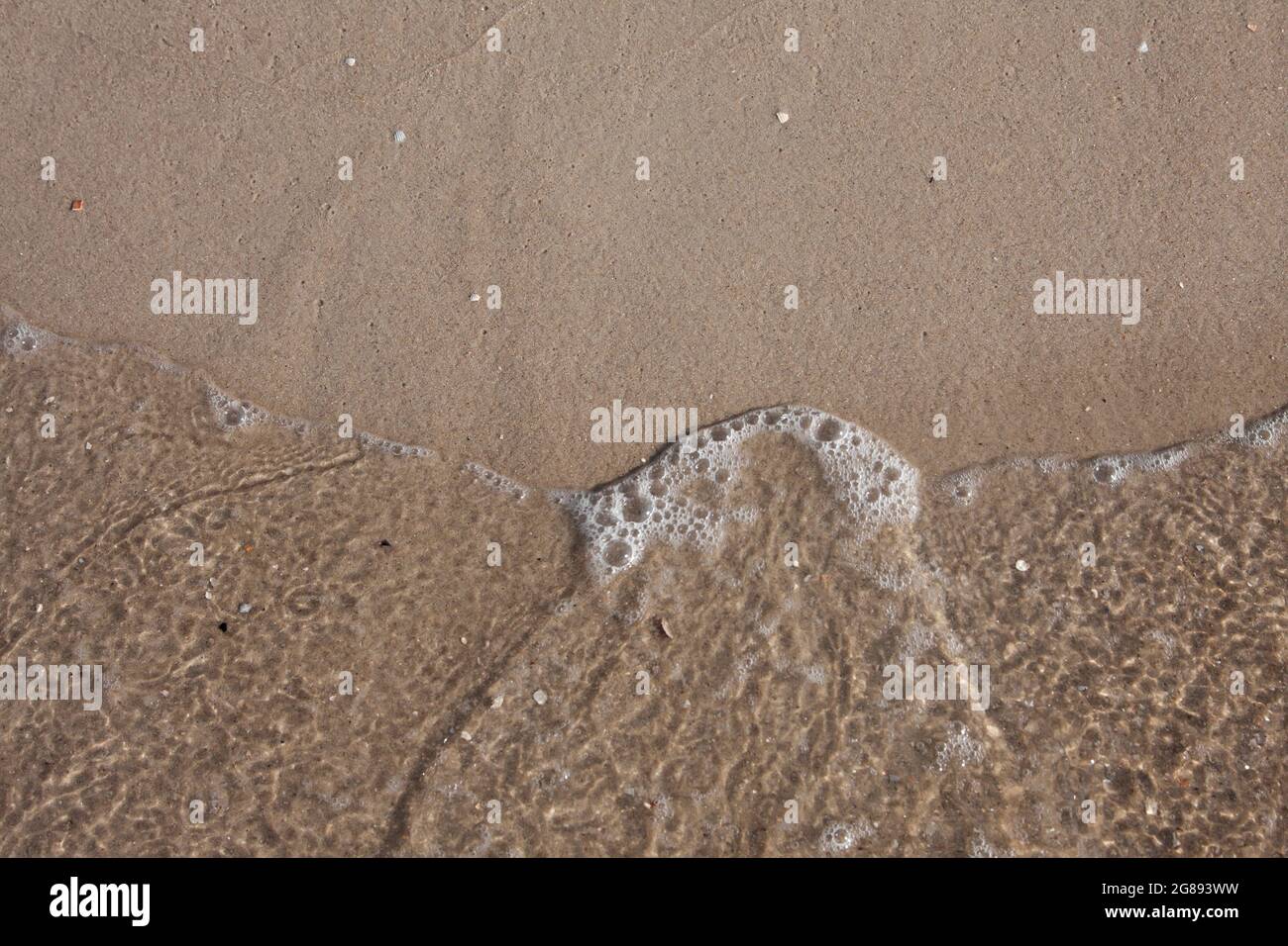 Close-up of a sea wave on a sandy beach. Top view. Sand beach texture ...