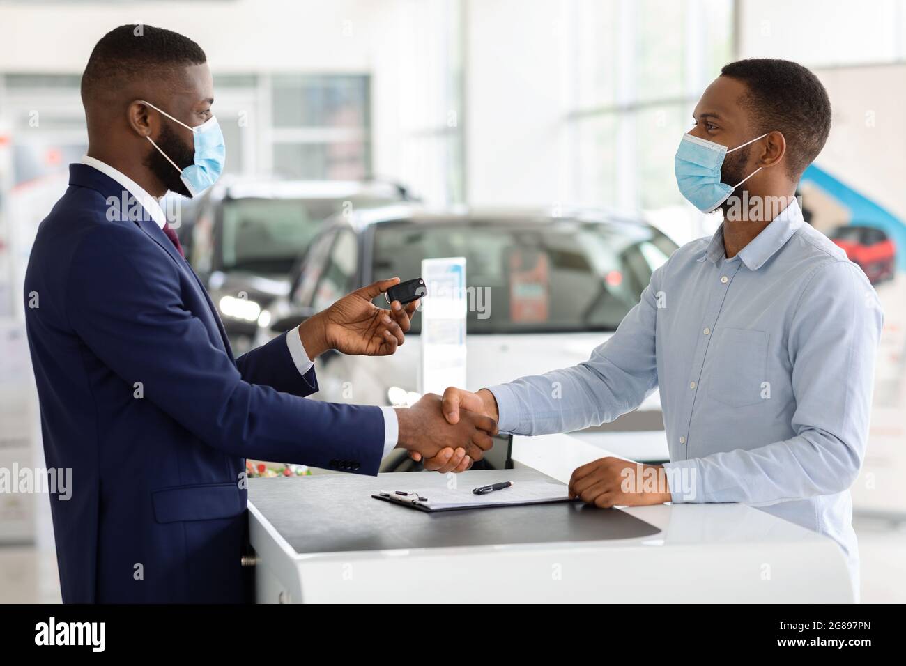 Black Salesman In Medical Mask Giving Key To Customer In Dealership ...