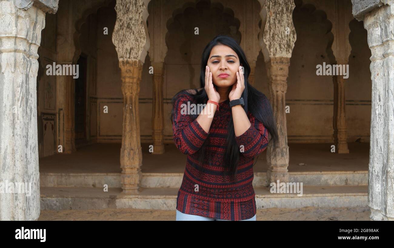 A young Indian female holding her cheeks Stock Photo - Alamy