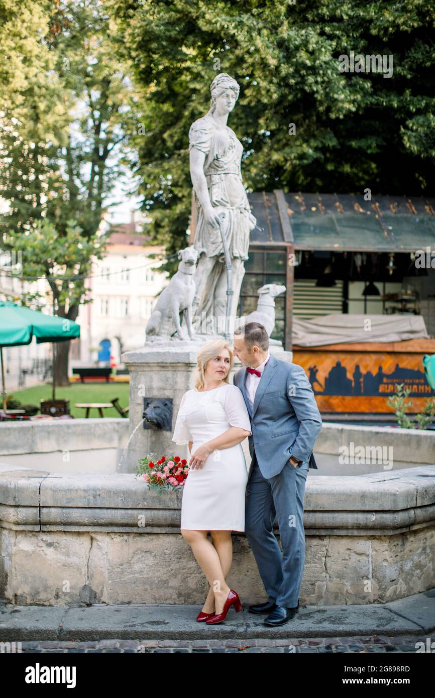 Loving middle-aged couple embracing while leaning backwards on the ...