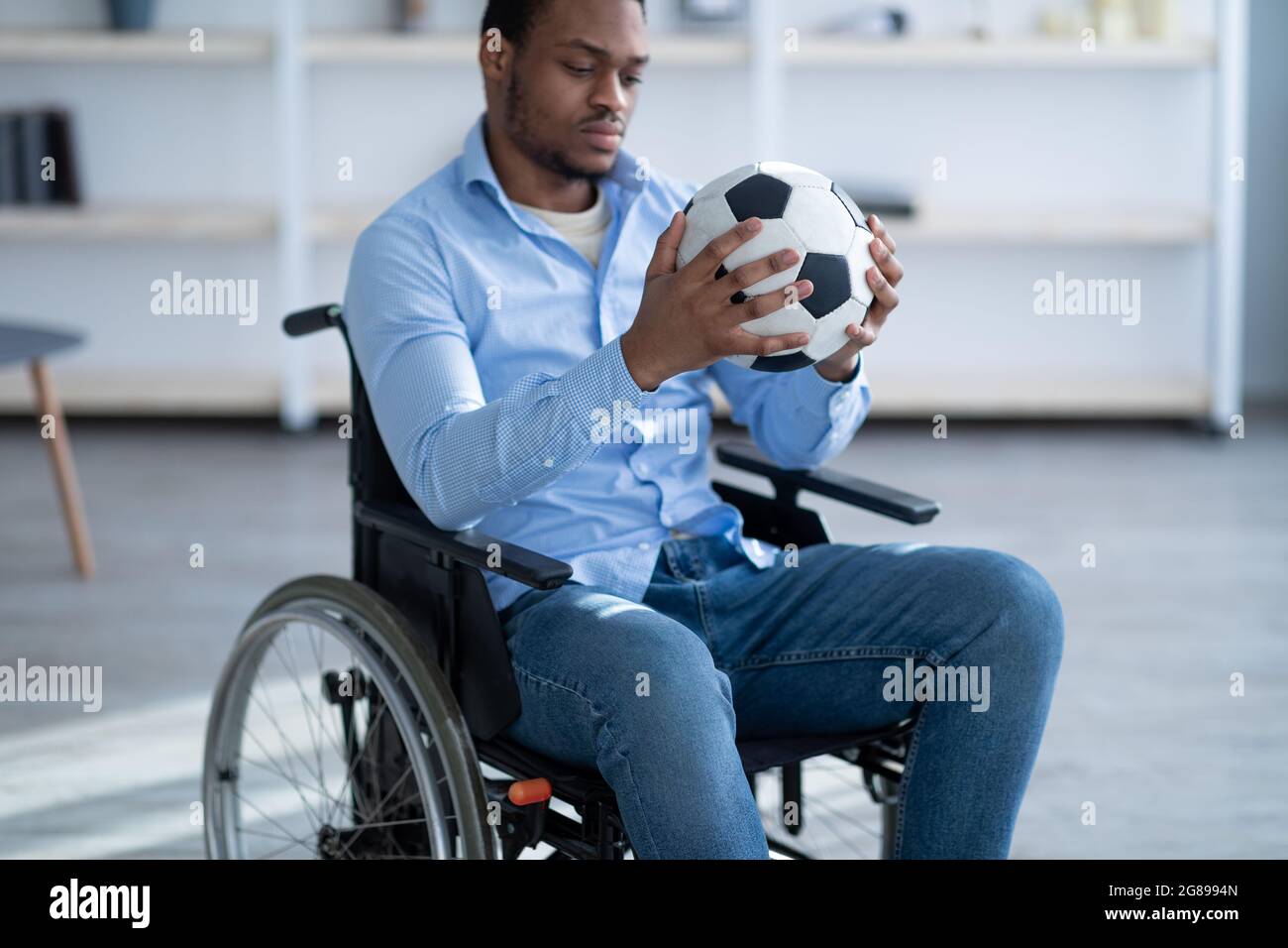 Handicapped black man with soccer ball sitting in wheelchair, feeling ...