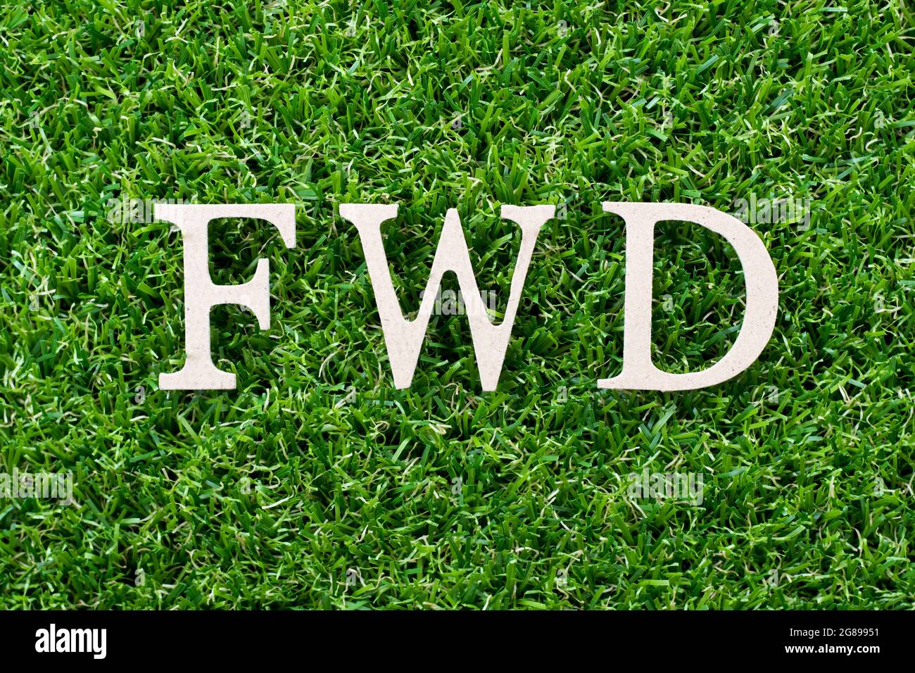 Wood letter in word FWD (Abbreviation of forward) on artificial green ...