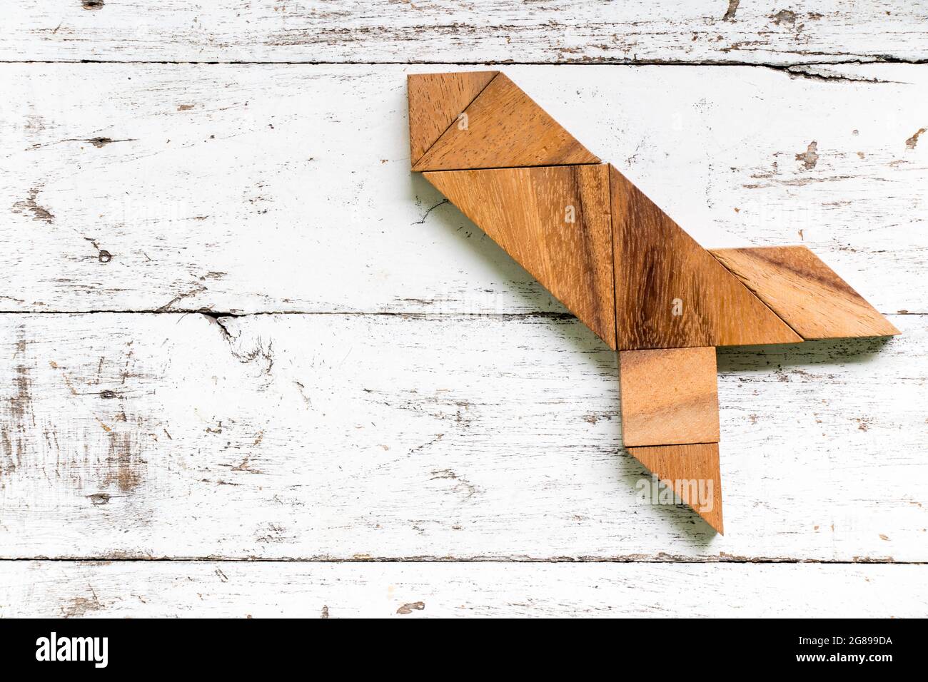 Tangram puzzle in missile or rocket shape on old white wood background ...
