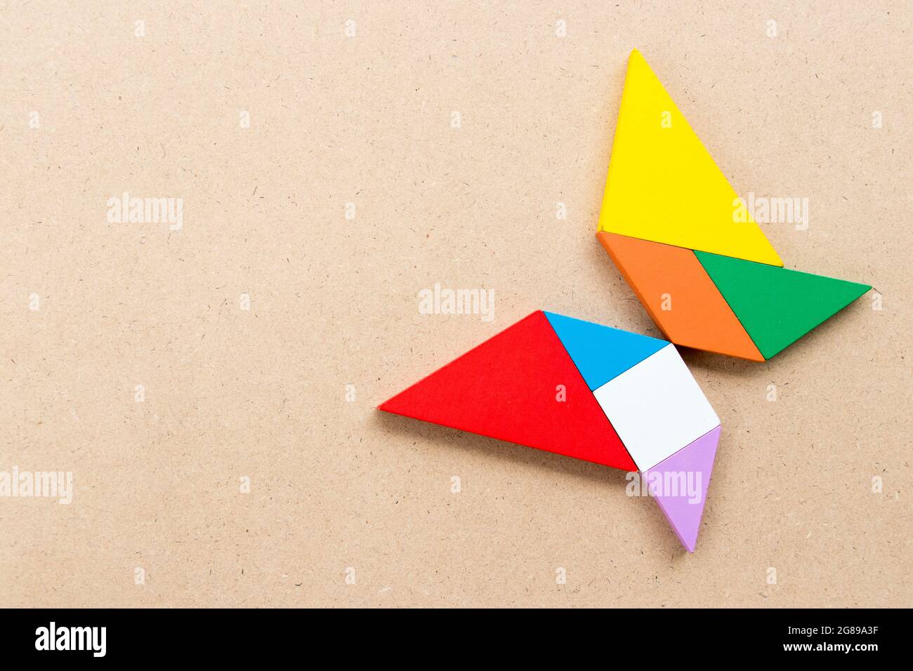Color tangram puzzle in butterfly shape on wood background Stock Photo ...