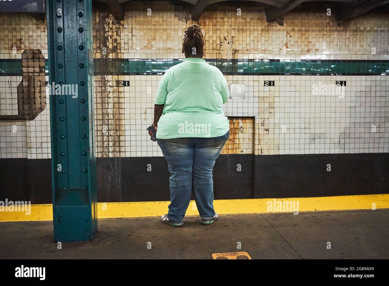 Woman waiting for the G train at 21st Street station in Queens Stock ...