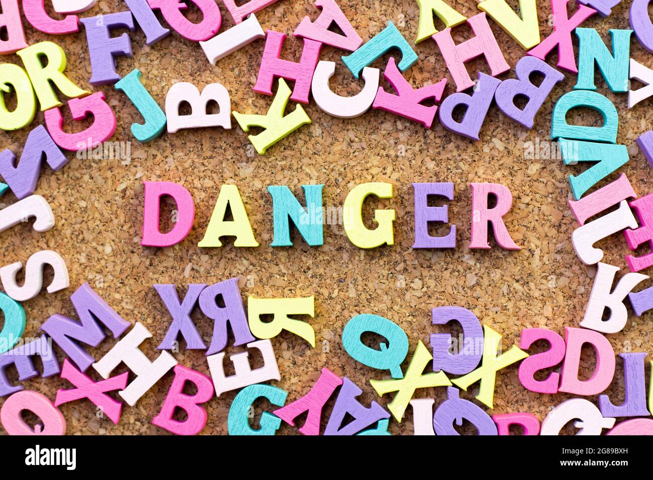Color alphabet in word danger with another letter as frame on cork ...