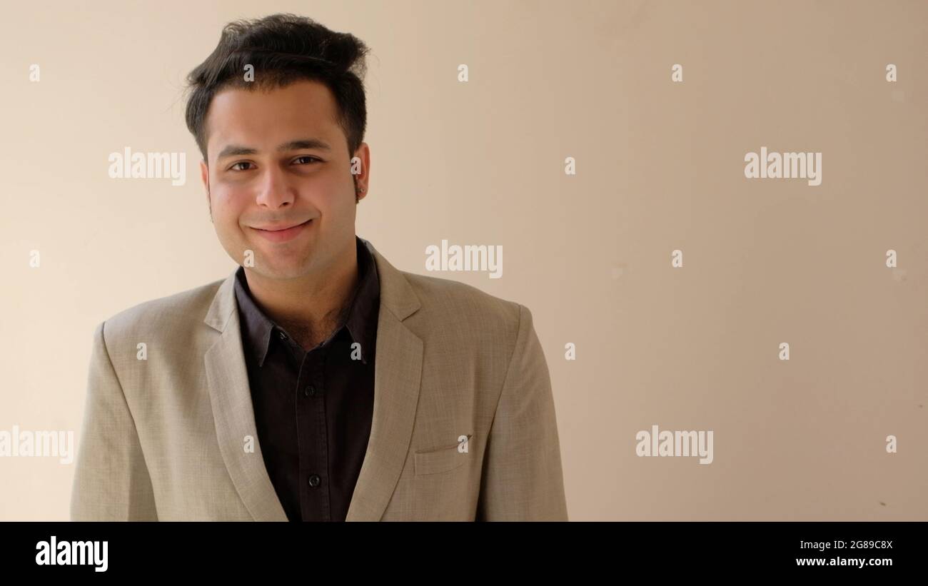 A smiling Indian male in an elegant suit on a beige background Stock ...
