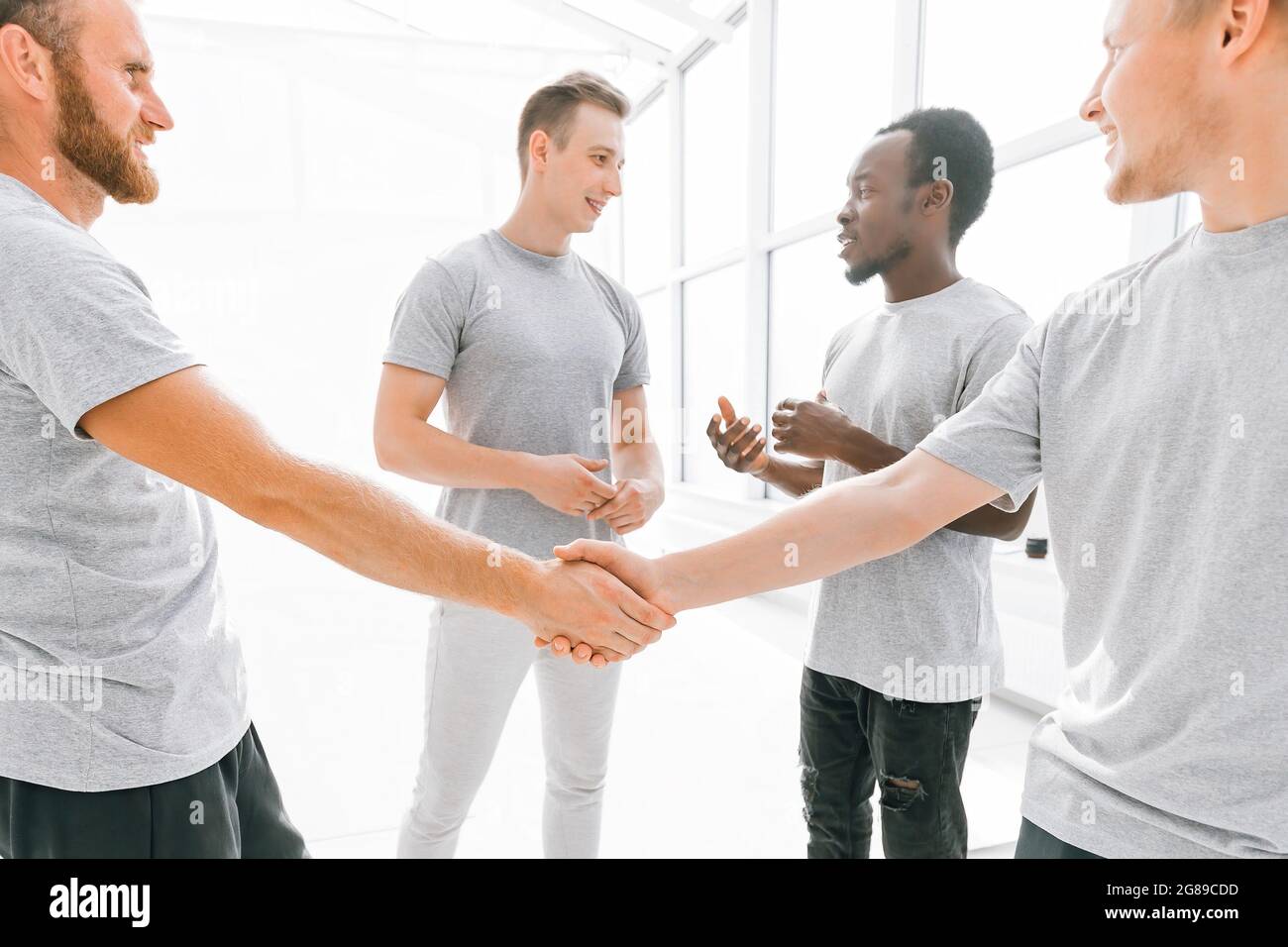 welcome handshake of friends in a bright office Stock Photo - Alamy