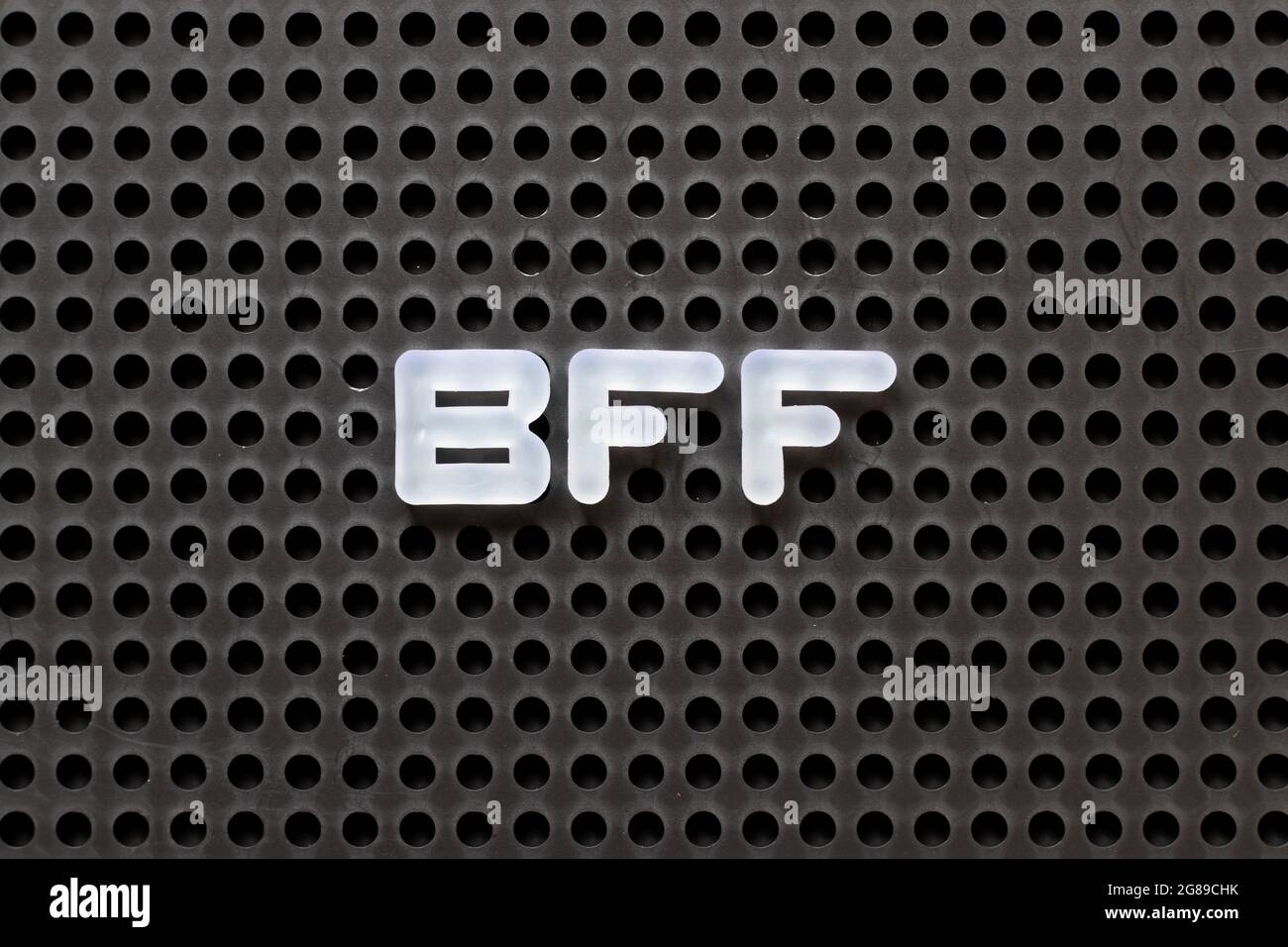 Black color pegboard with white letter in word BFF (Abbreviation of ...