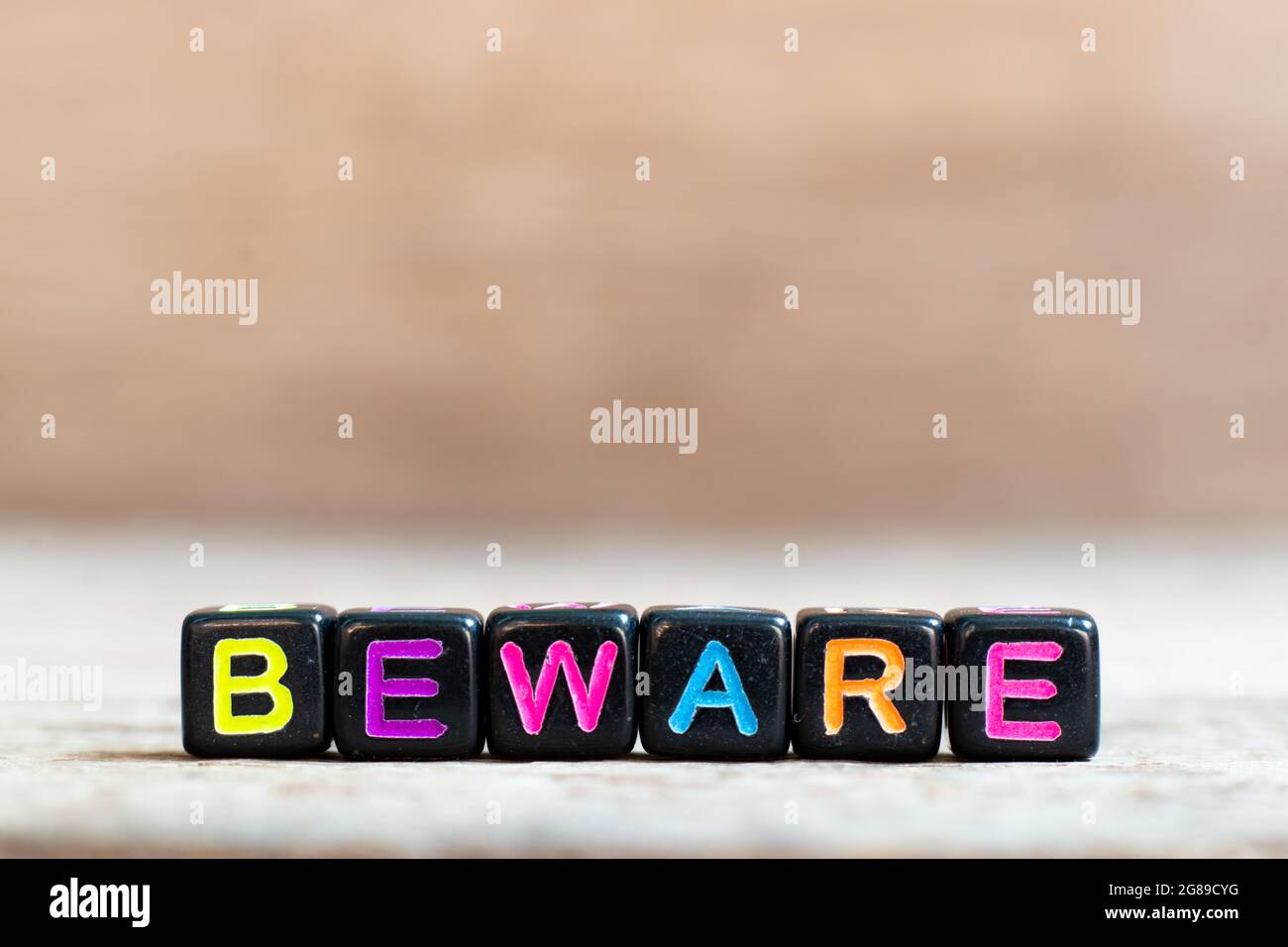 Black bead with color alphabet in word beware on wood background Stock ...