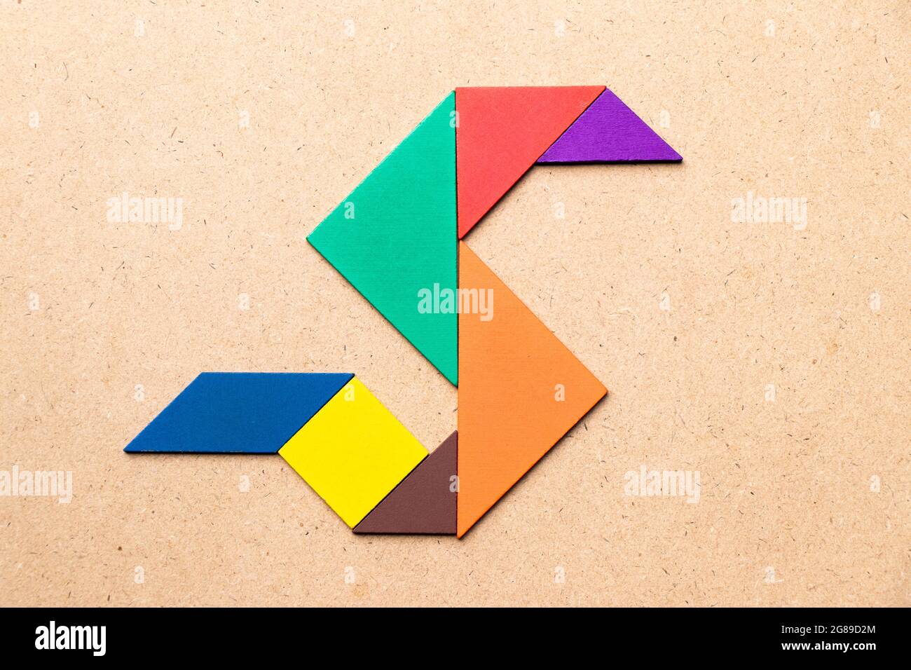 Color tangram puzzle in snake or dragon shape on wood background Stock ...