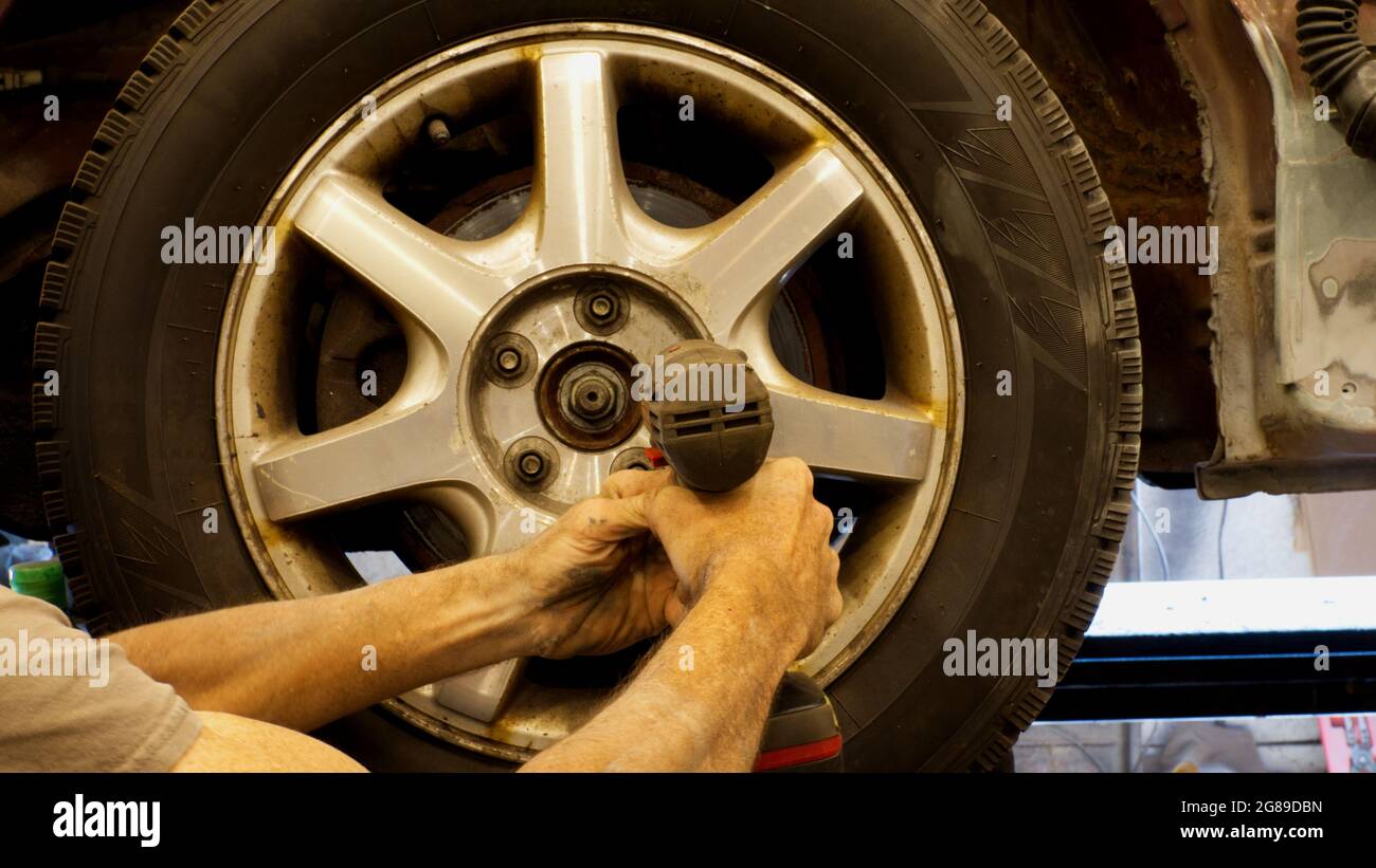 A Person Removes a Wheel and Tire on a Car Stock Photo - Alamy