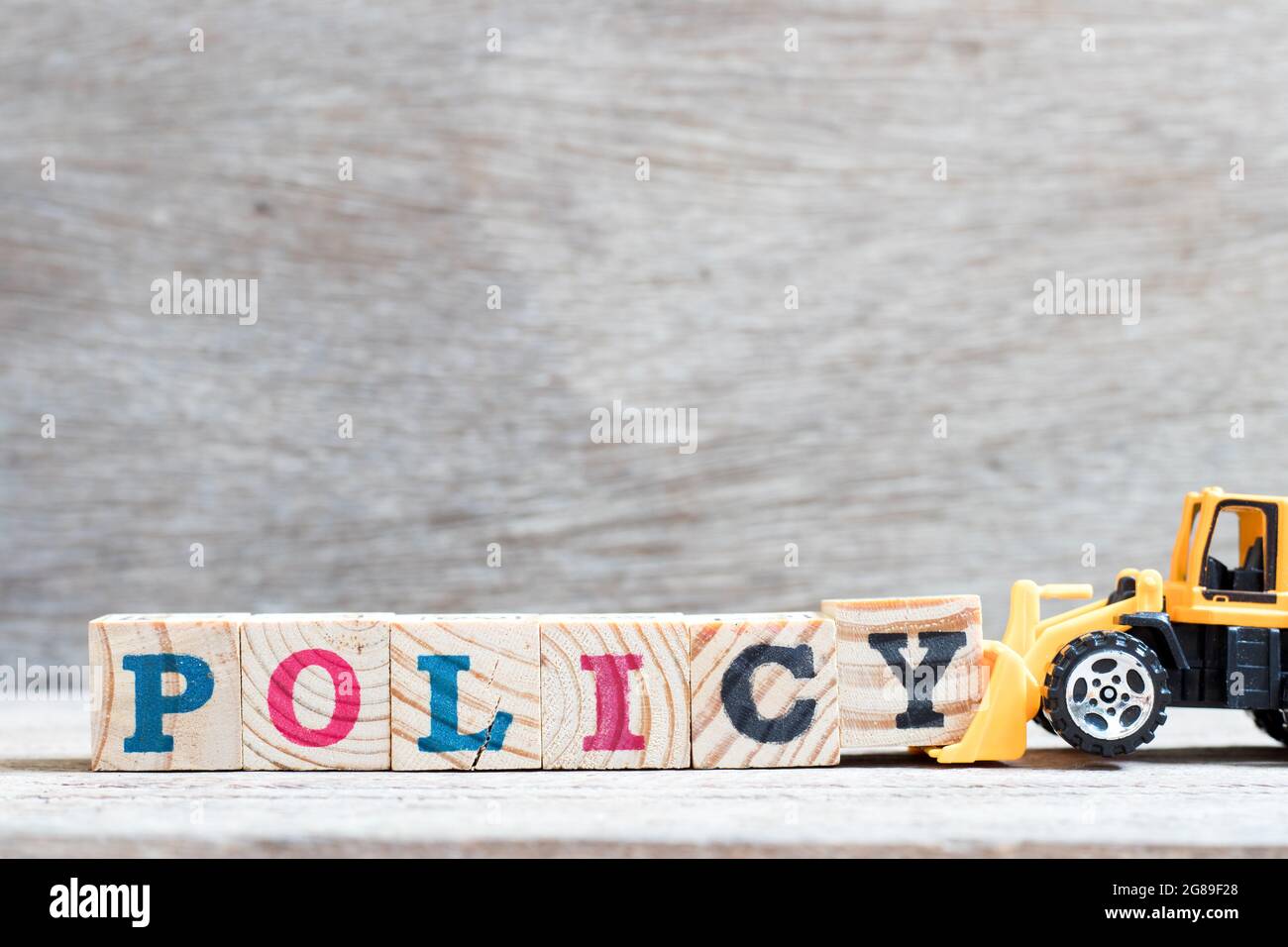Toy bulldozer hold letter block y to complete word policy on wood ... Toy bulldozer hold letter block y to complete word policy on wood ...