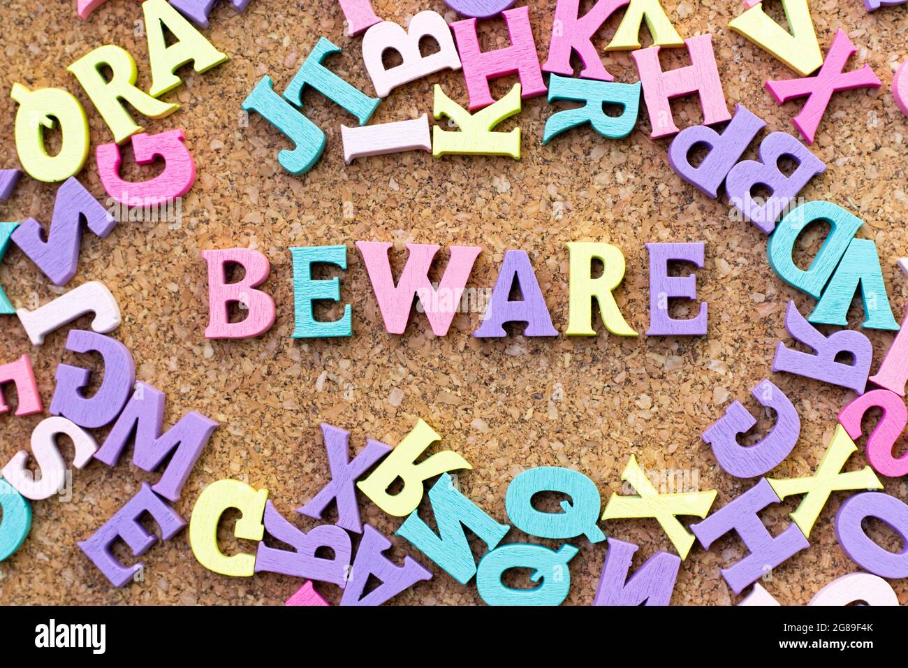 Color alphabet in word beware with another letter as frame on cork ...