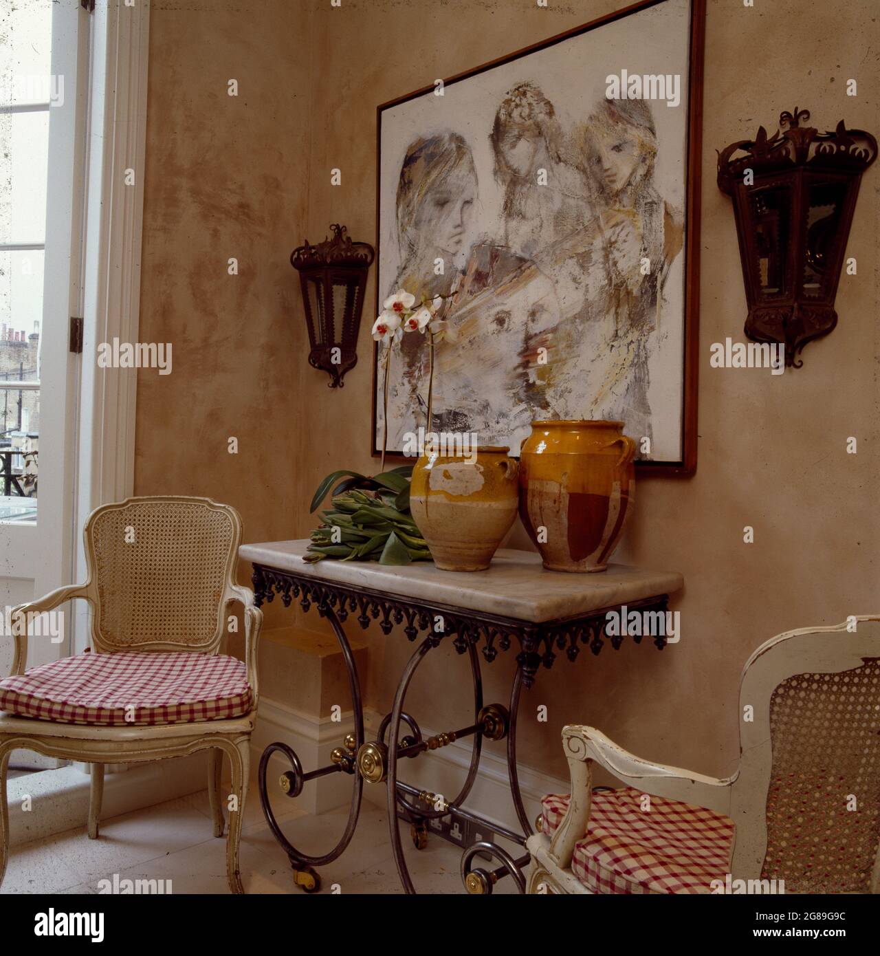 Marble topped metal side table with pots and orchid Stock Photo - Alamy
