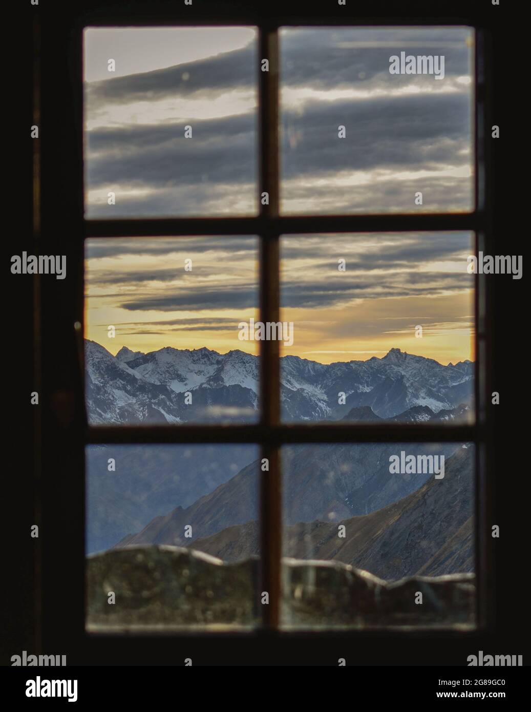 view through the rustic window of an alpine mountain hut against the ...