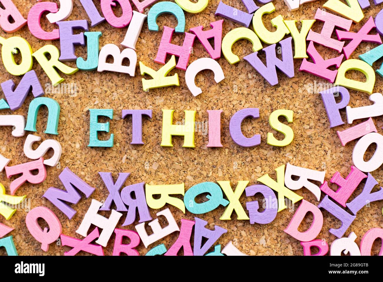 Color alphabet in word ethics with another letter as frame on cork ...