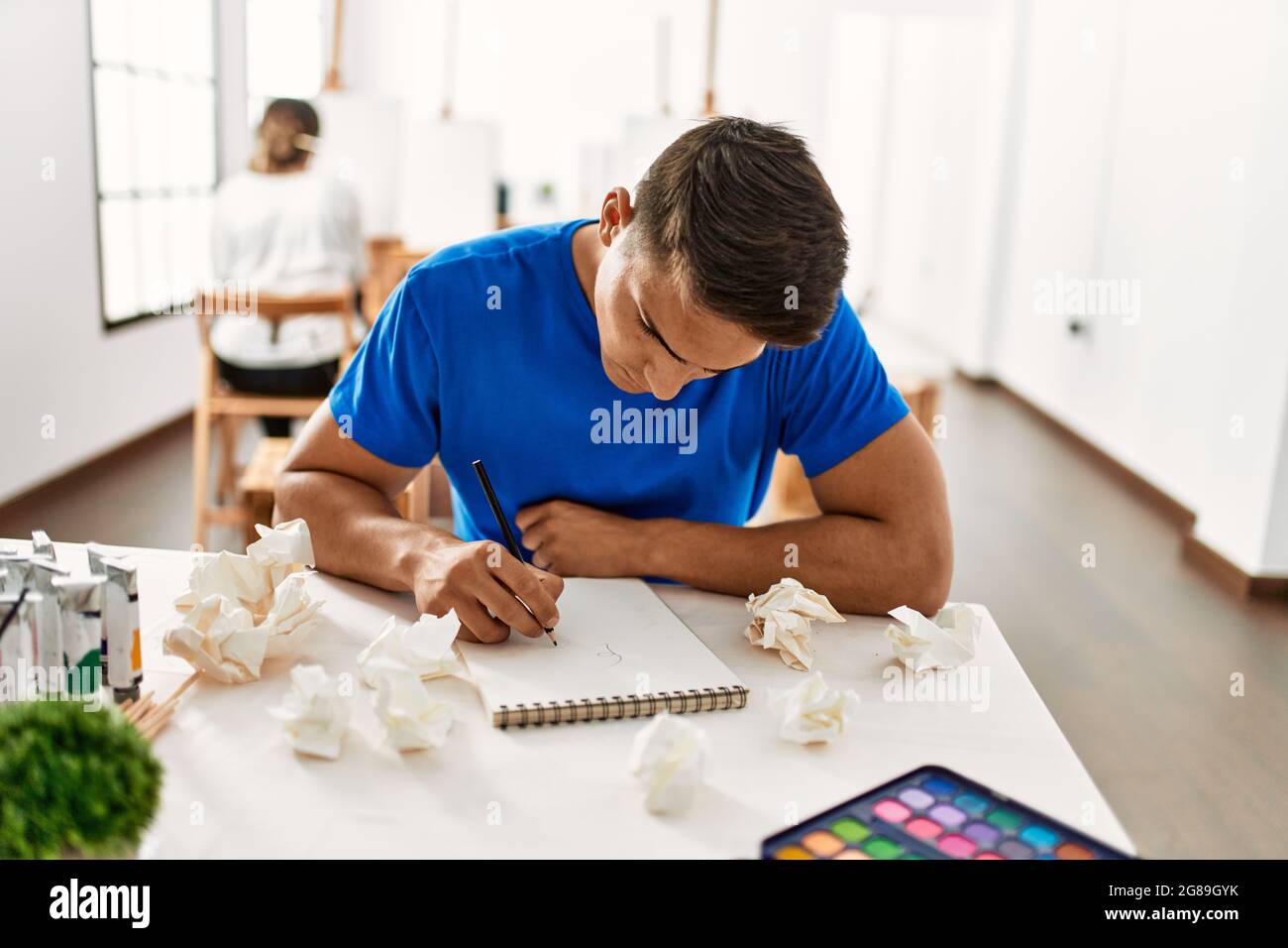 Paint student man stressed painting at art school Stock Photo - Alamy
