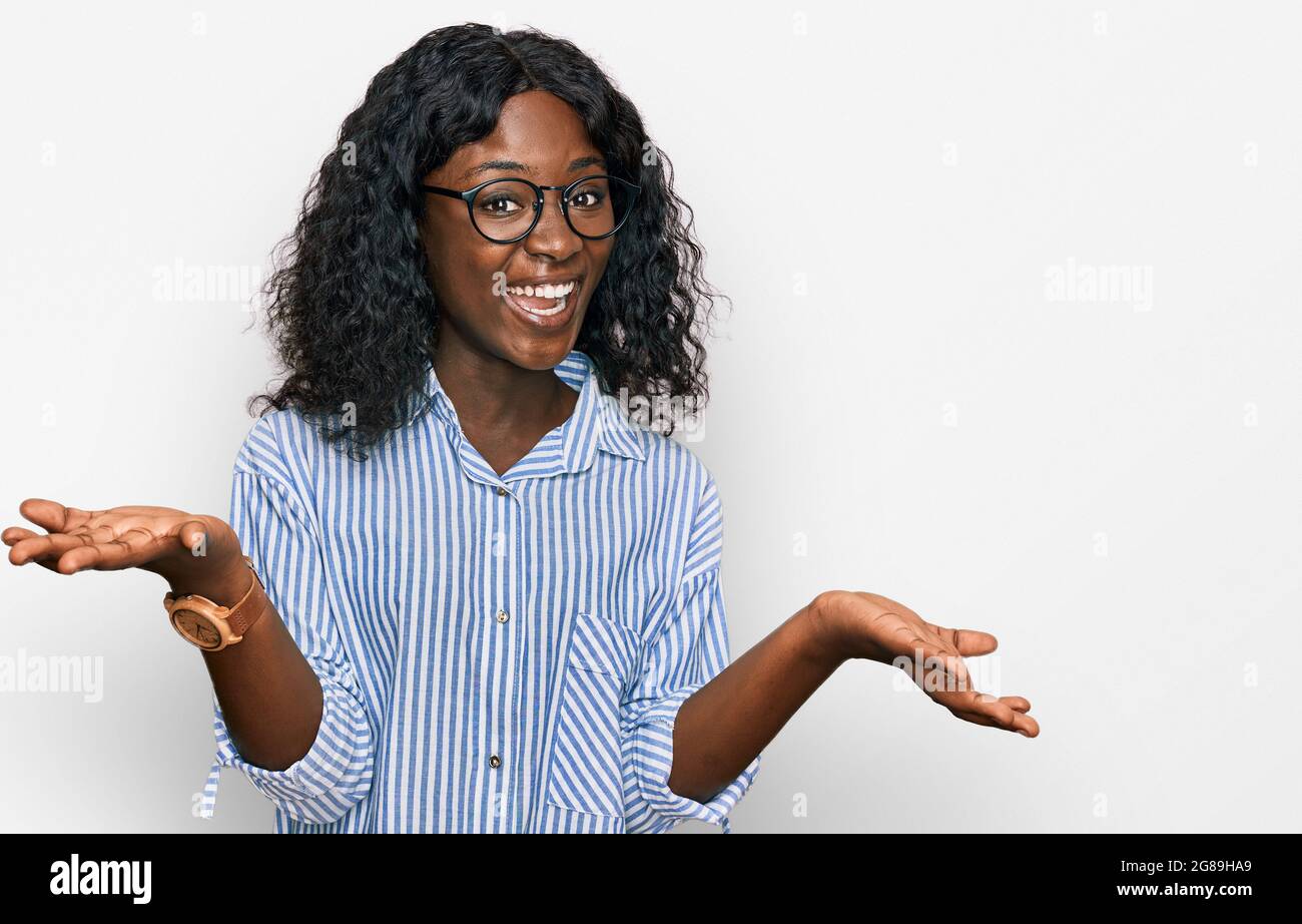 Beautiful african young woman wearing casual clothes and glasses ...