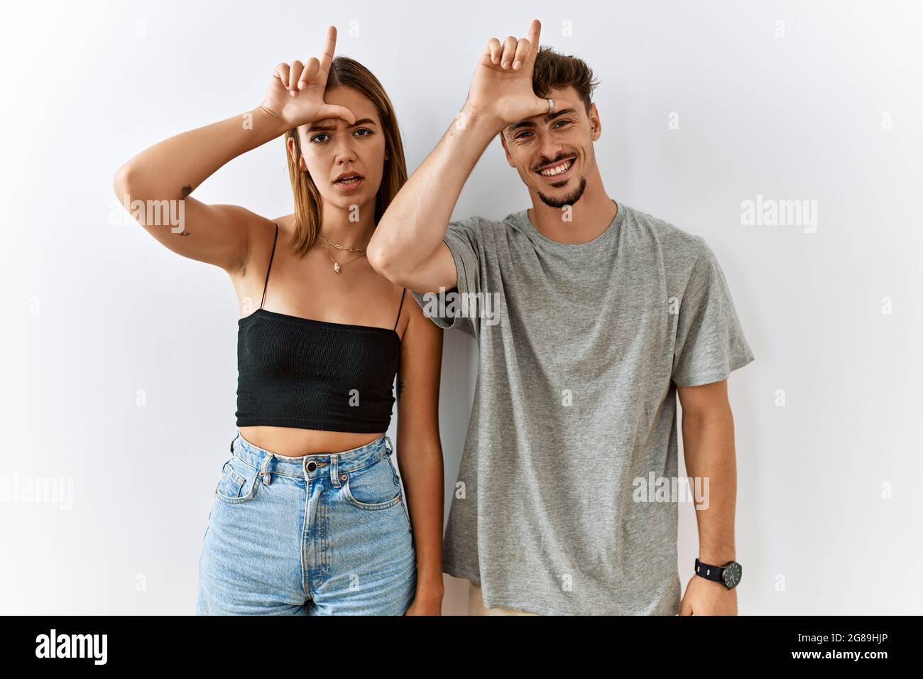 Young beautiful couple standing together over isolated background ...