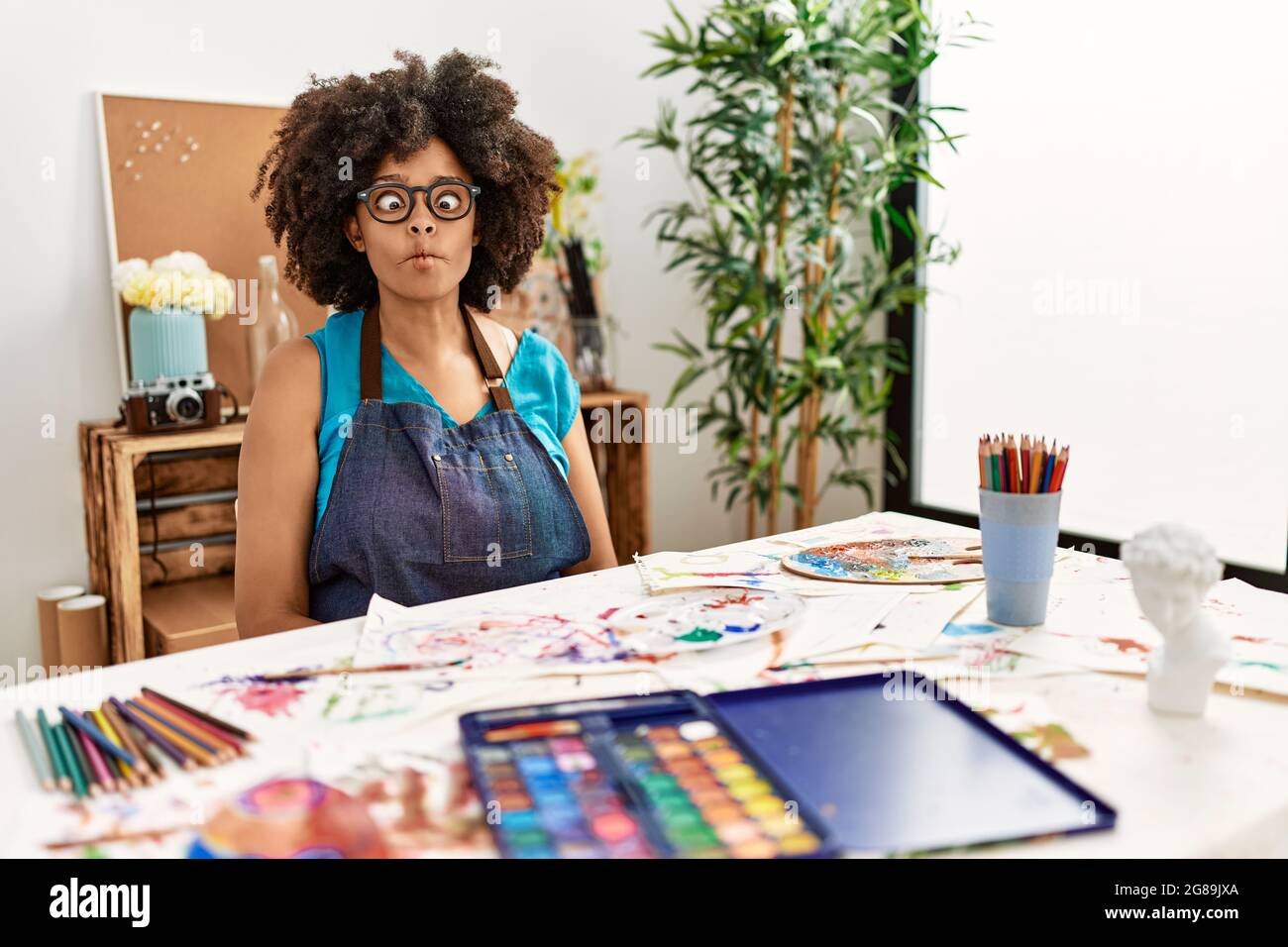 Beautiful african american woman with afro hair painting at art studio ...