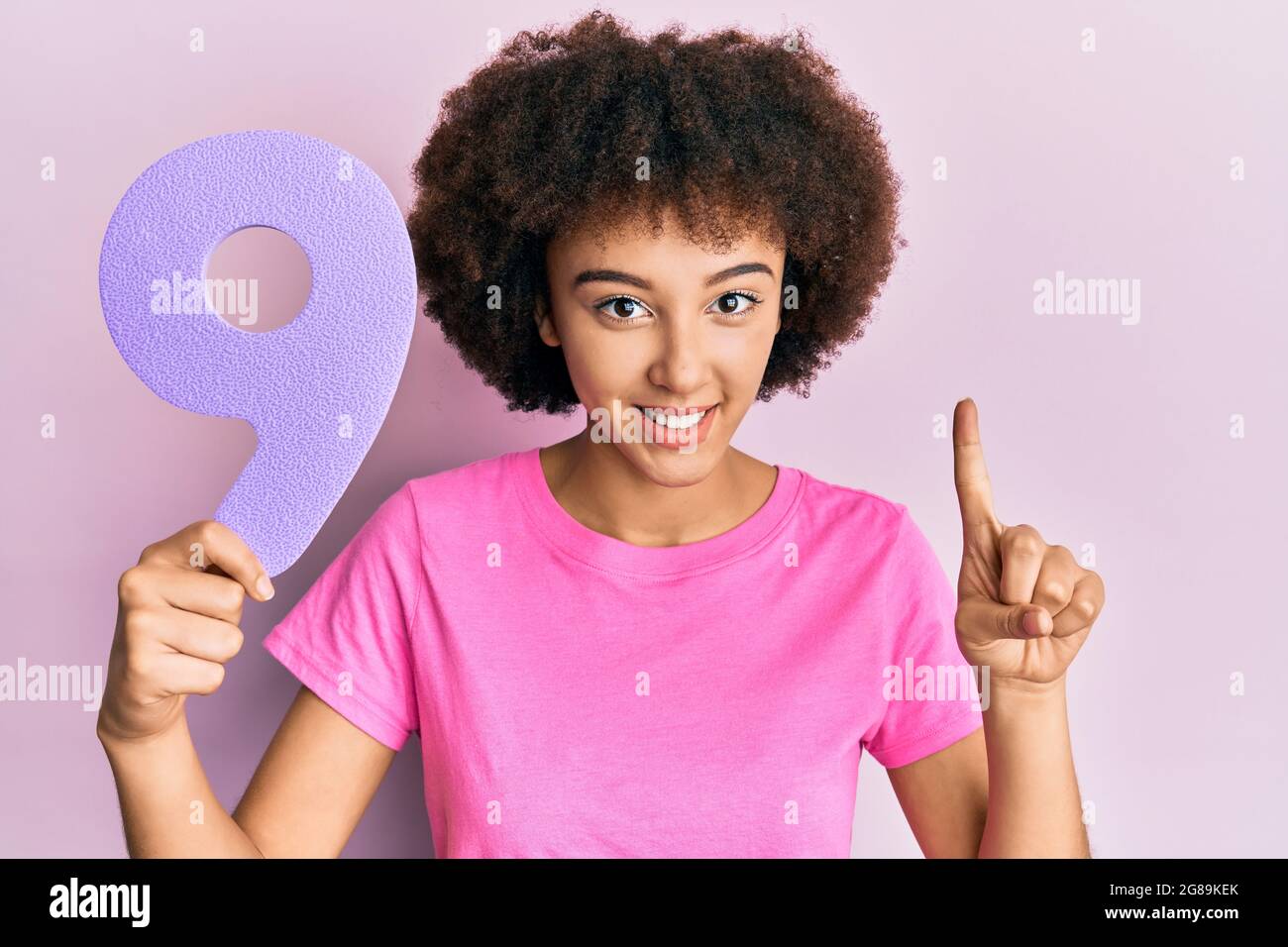 Young hispanic girl holding number nine smiling with an idea or ...