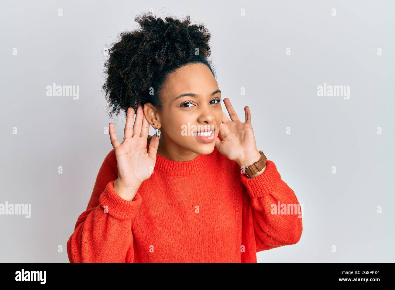 Young african american girl wearing casual clothes trying to hear both ...