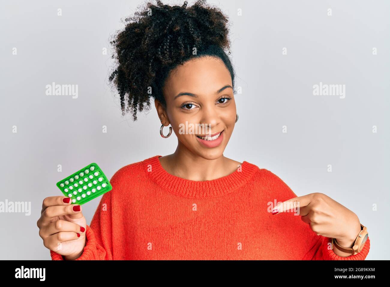 Young African American Girl Holding Birth Control Pills Pointing Finger