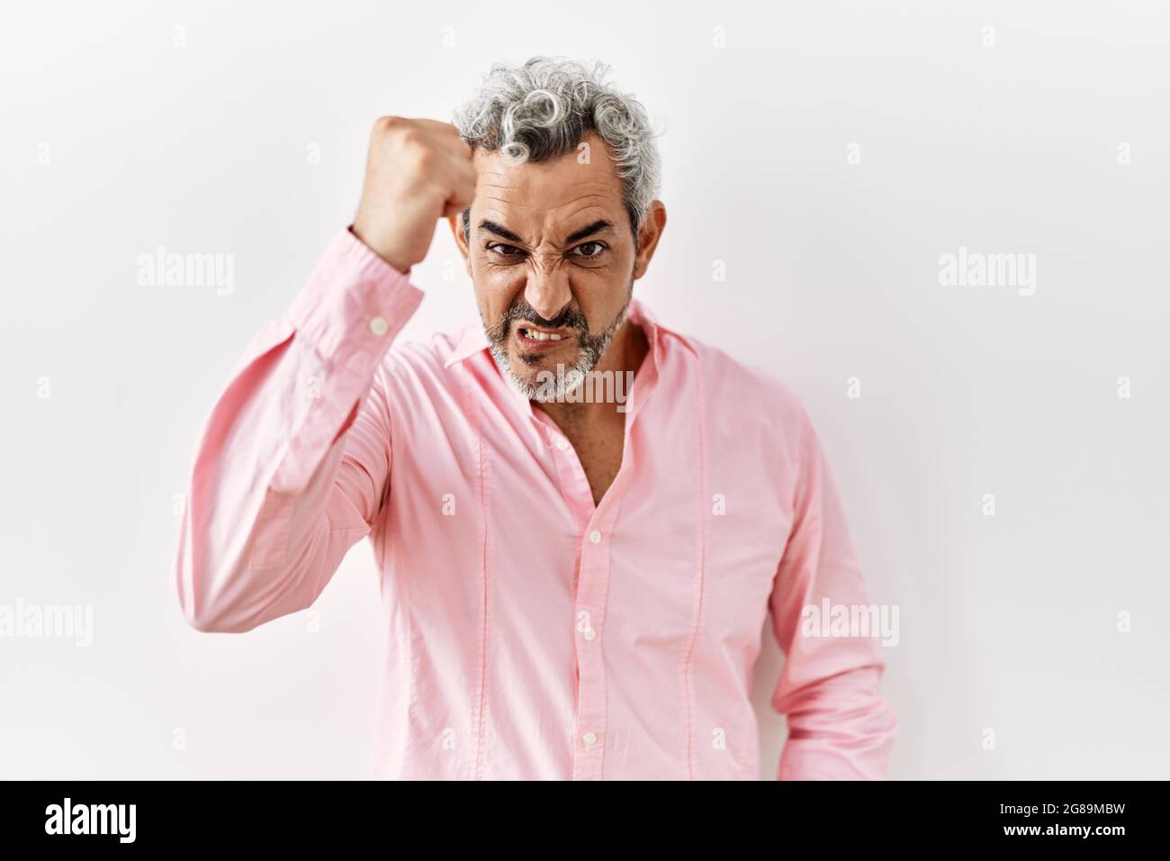 Middle age hispanic man standing over isolated background angry and mad ...