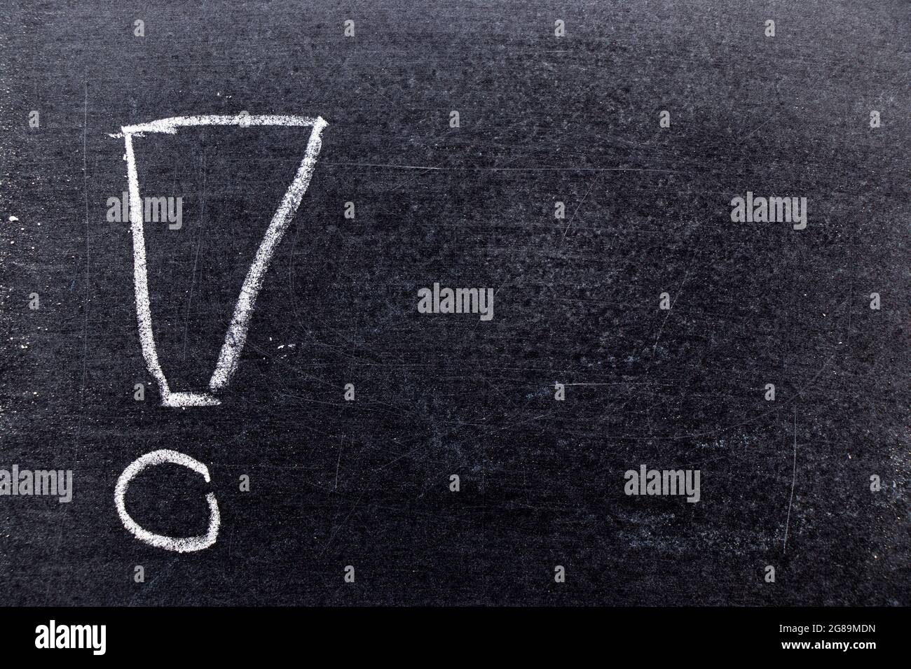 White color chalk hand drawing in exclamation mark with blank space ...