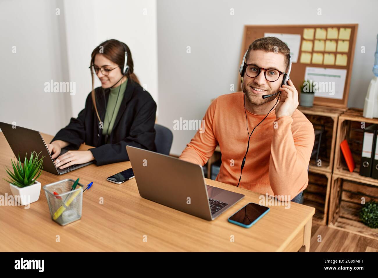 Two caucasian call center agents working at the office Stock Photo - Alamy