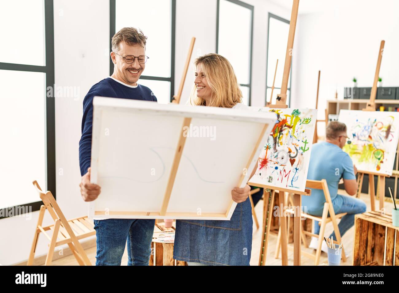 Group of middle age people drawing at art studio. Two students smiling ...