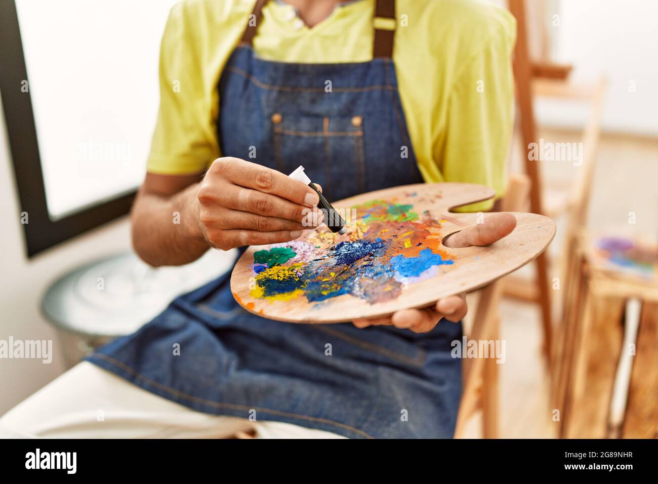 Artist man mixing colors on palette at art studio Stock Photo - Alamy