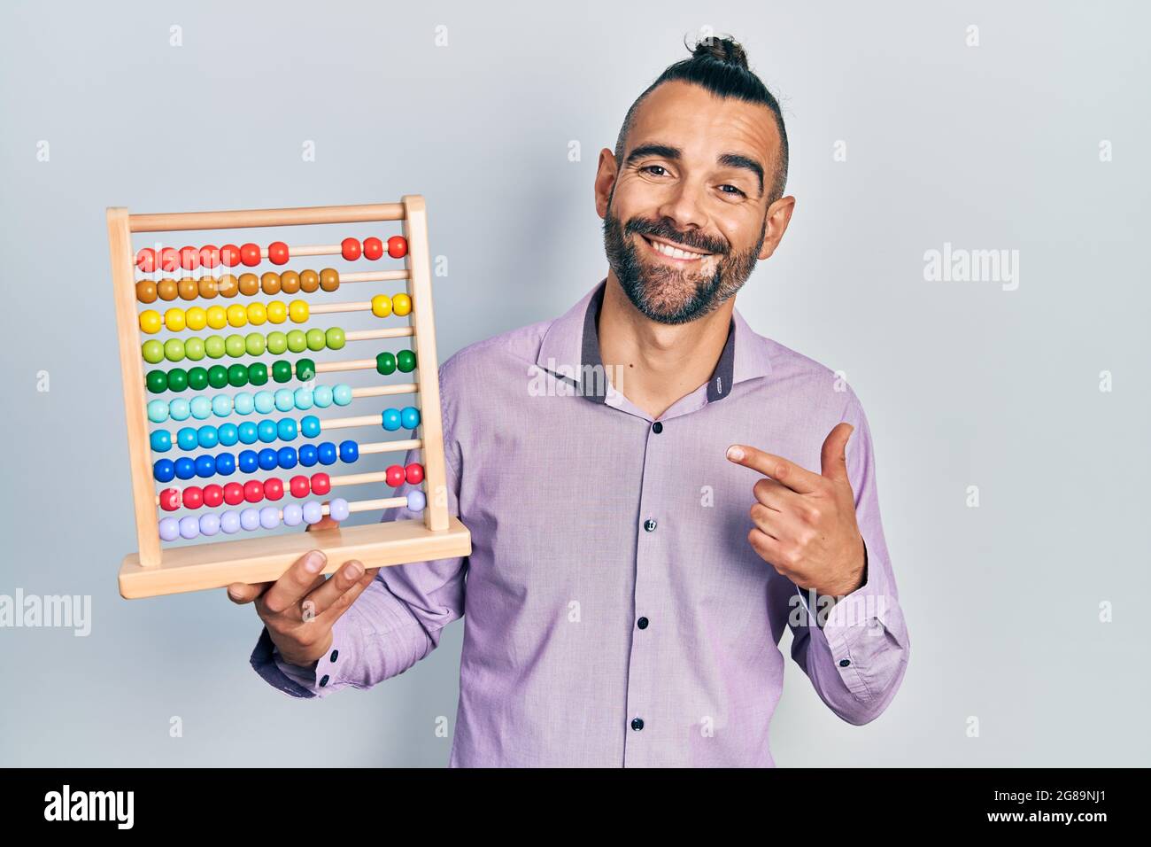 Young hispanic man holding traditional abacus smiling happy pointing ...