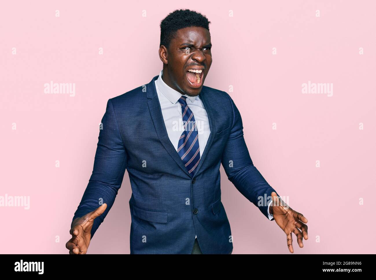 Handsome business black man wearing business suit and tie crazy and mad ...