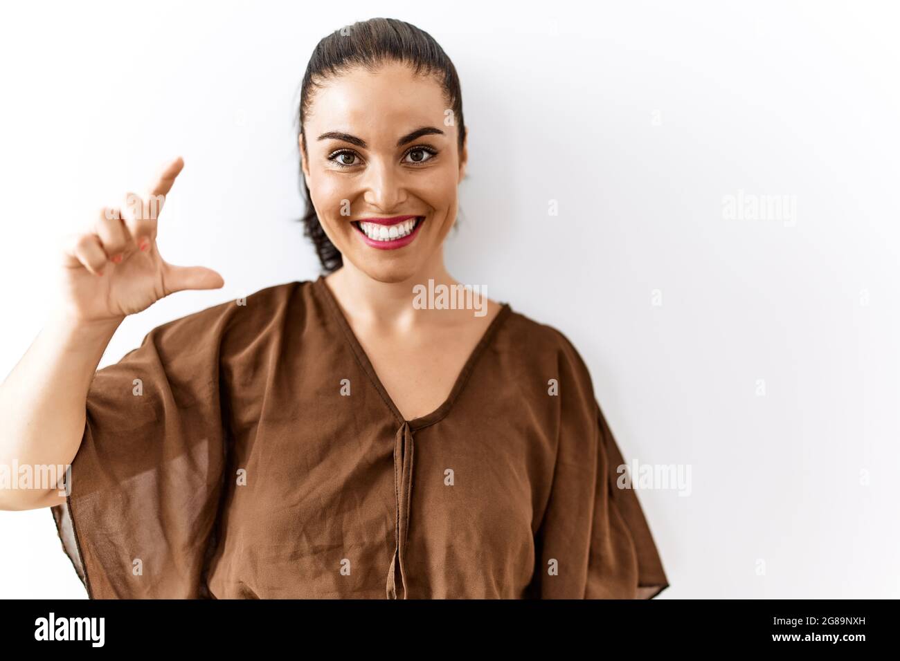 Young brunette woman standing over isolated background smiling and ...