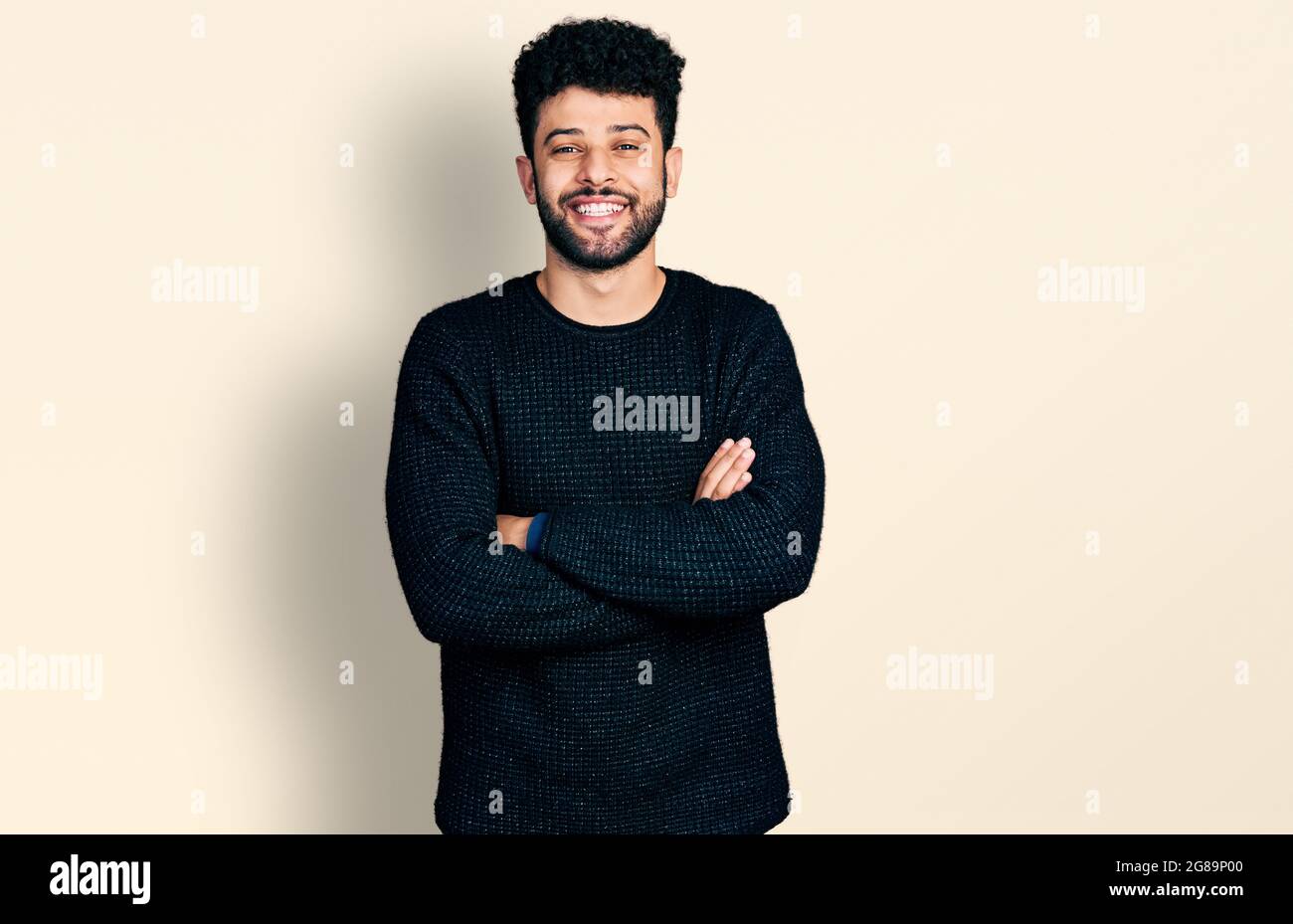 Young arab man with beard with arms crossed gesture smiling and ...