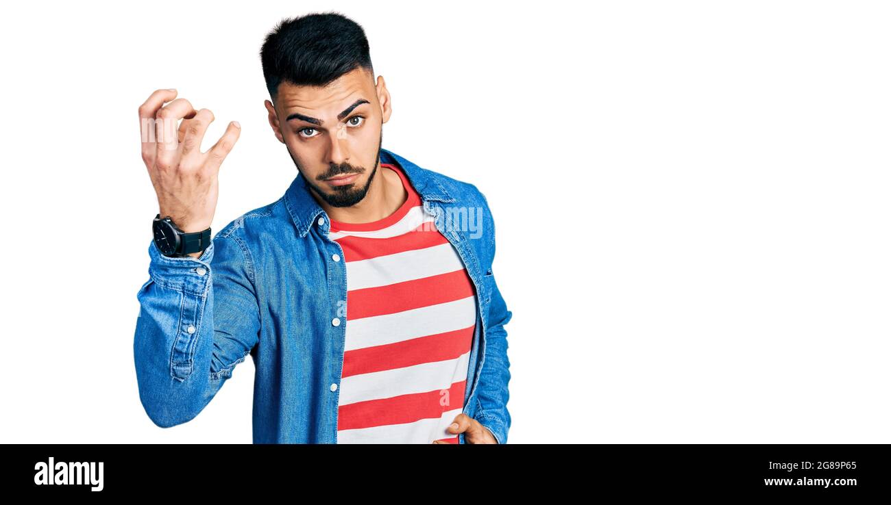 Young hispanic man with beard wearing casual denim jacket doing italian ...
