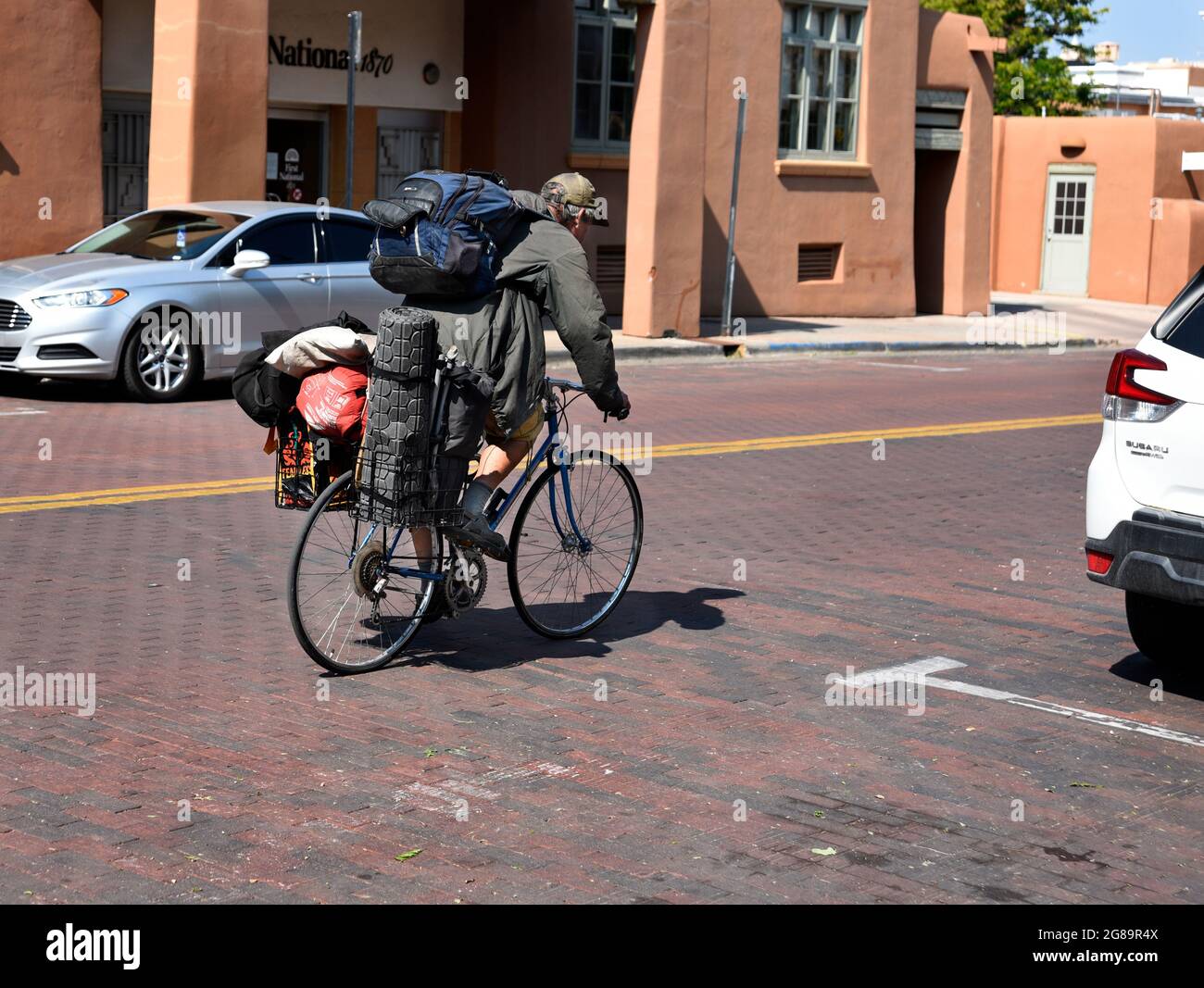 A homeless man rides a bicycle along a street in downtown Santa Fe, New ...