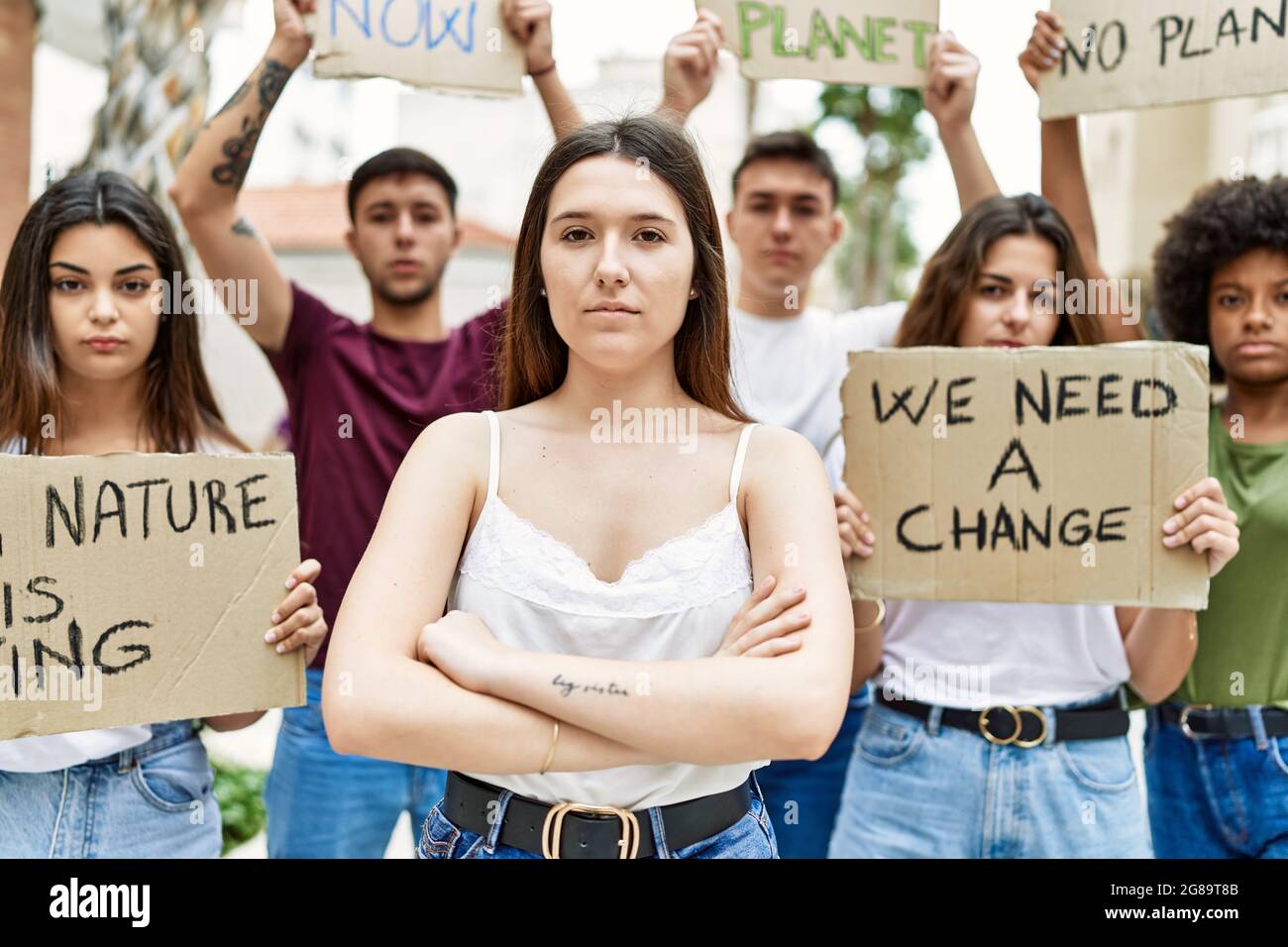 Young activist woman with arms crossed gesture standing with a group of ...
