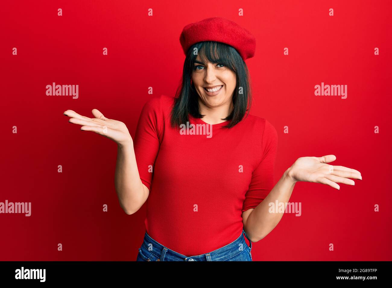 Young hispanic woman wearing french look with beret clueless and ...