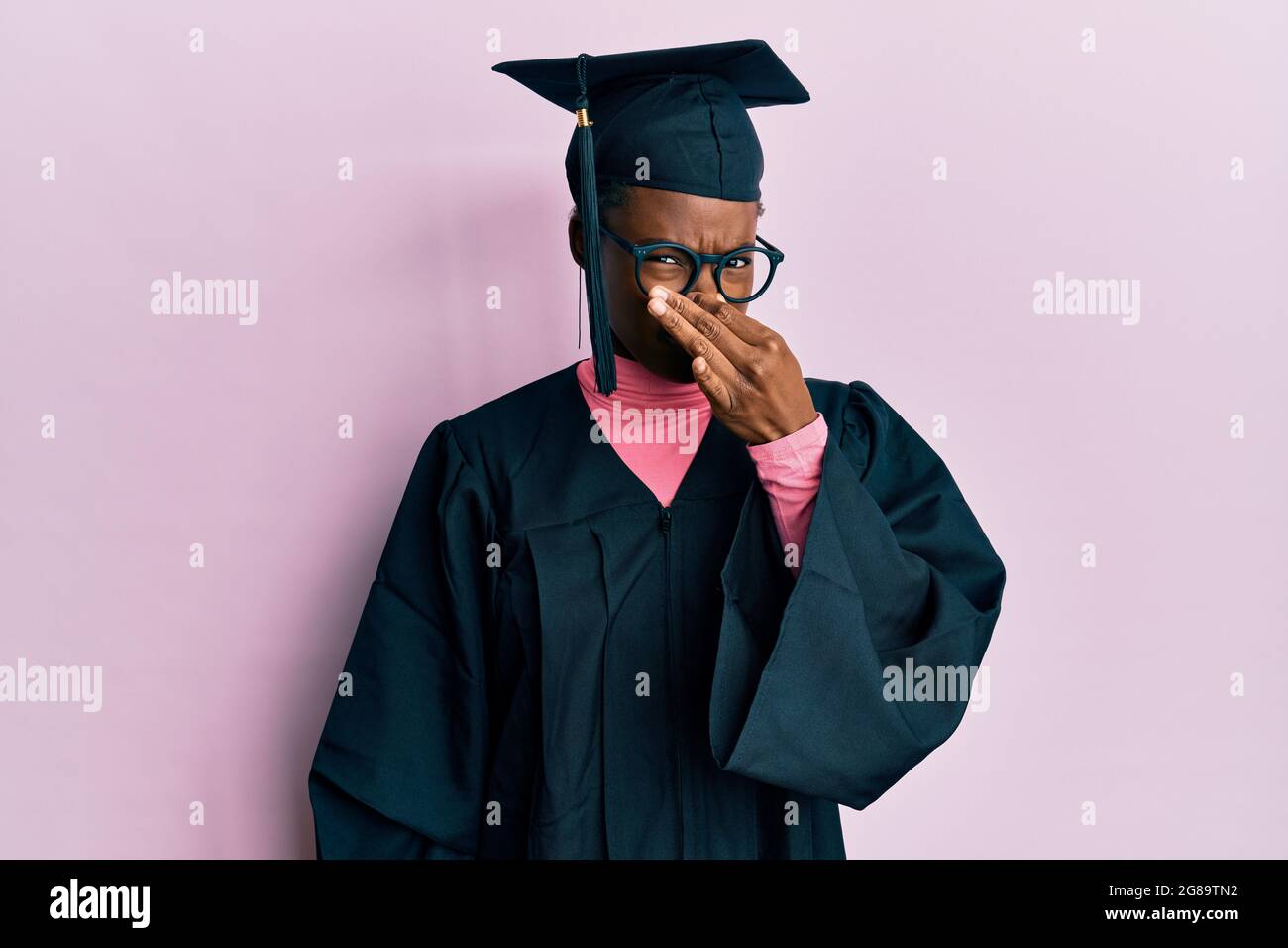 Young african american girl wearing graduation cap and ceremony robe ...
