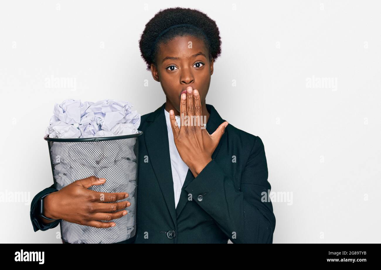 Young african american girl holding paper bin full of crumpled papers ...