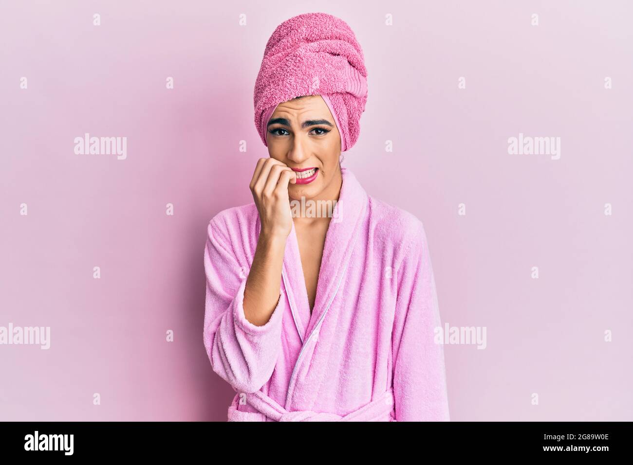 Young man wearing woman make up wearing shower towel on head and ...