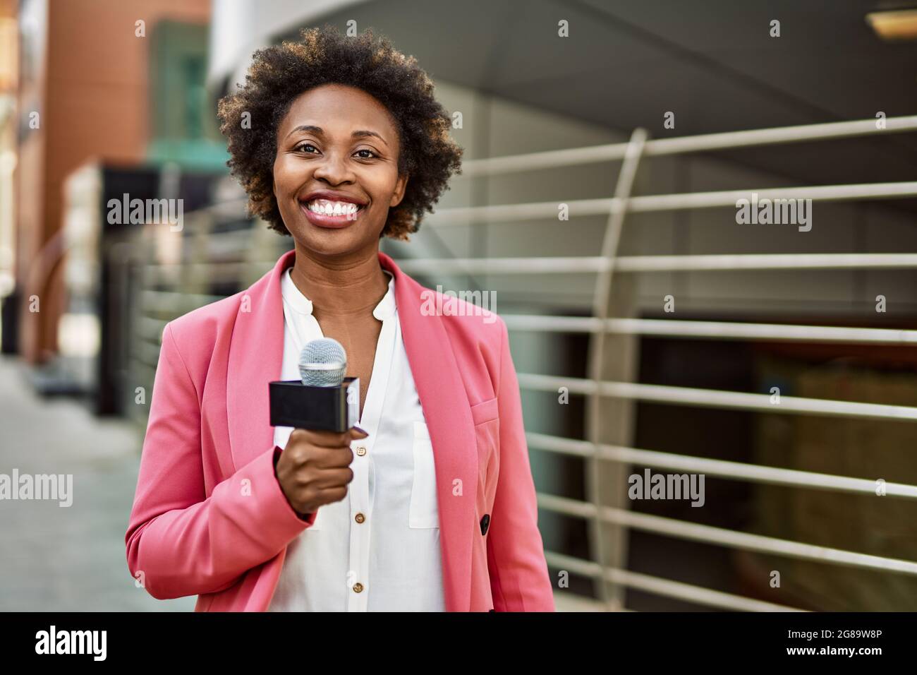 Young african american woman journalist holding reporter microphone ...
